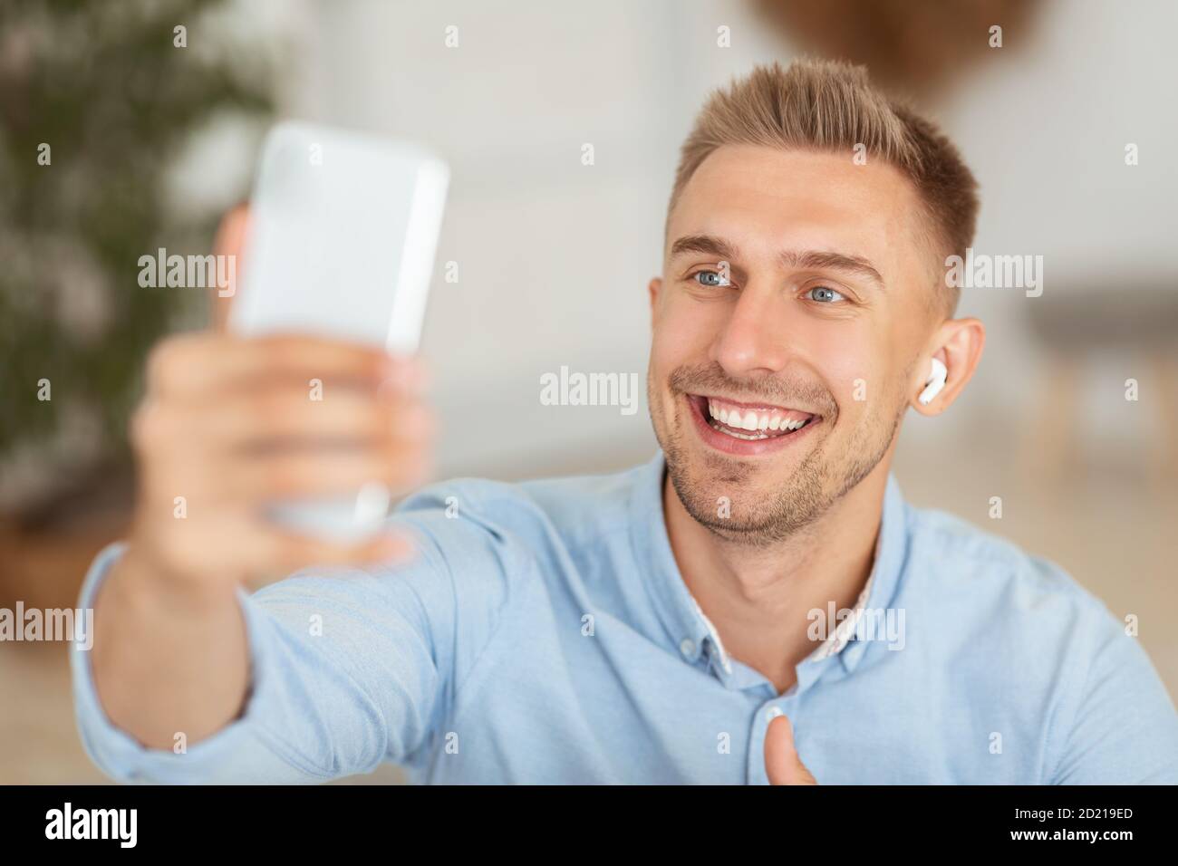 Happy guy using mobile phone for video call Stock Photo - Alamy