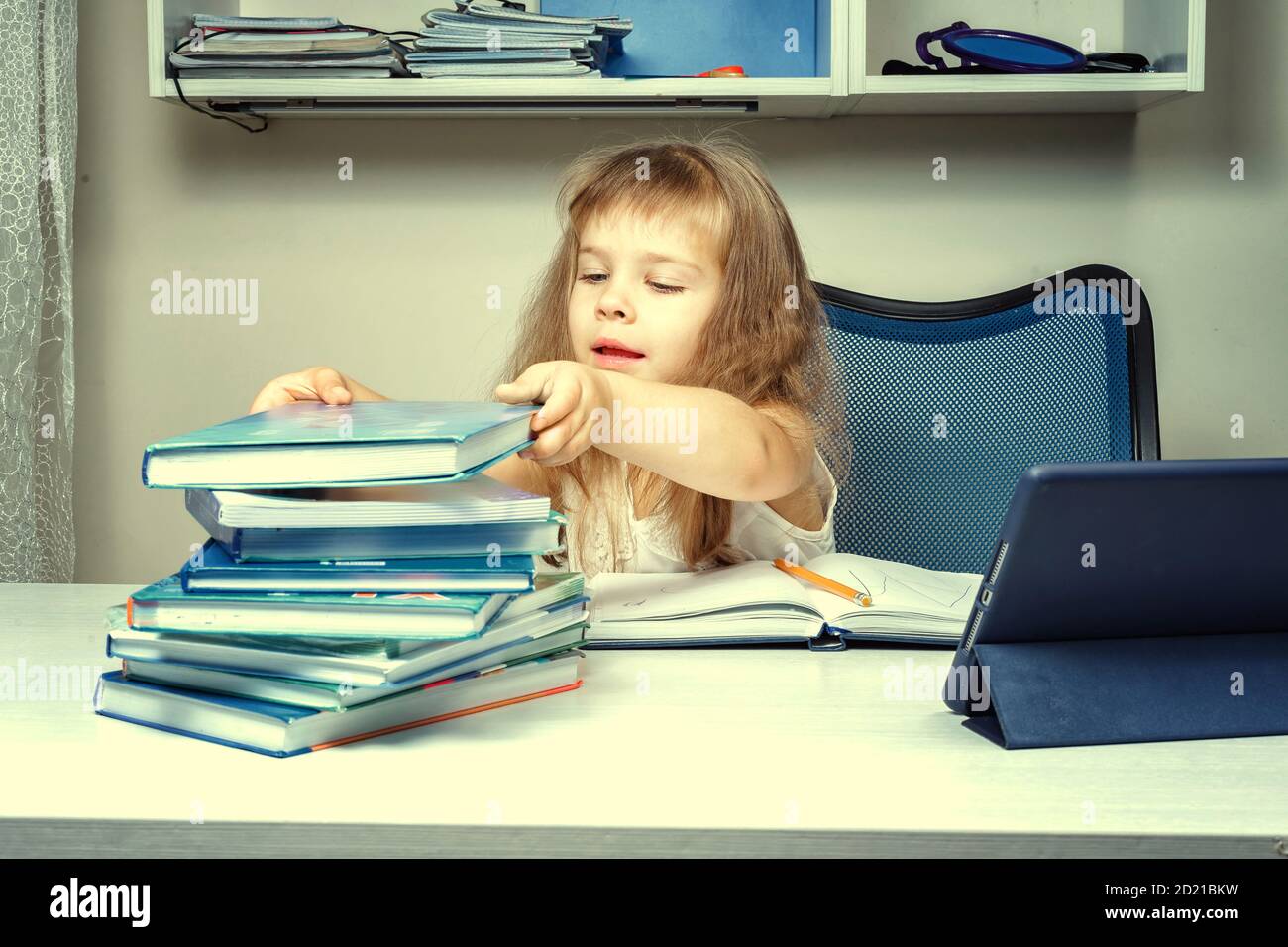 online classes in quarantine. girl takes a book from a pile. zoom ...