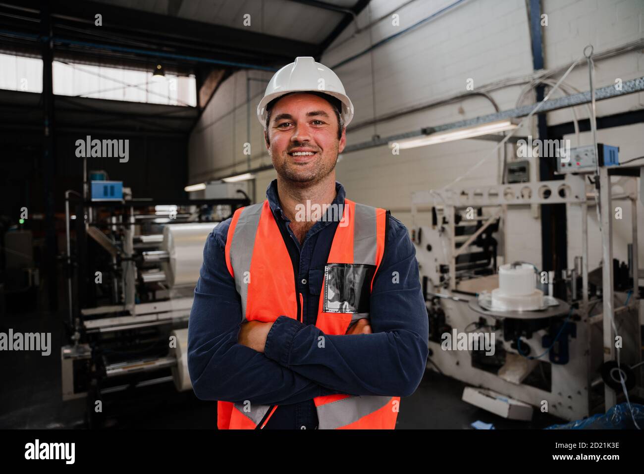 Male engineer standing smiling with crossed arms in factory Stock Photo ...