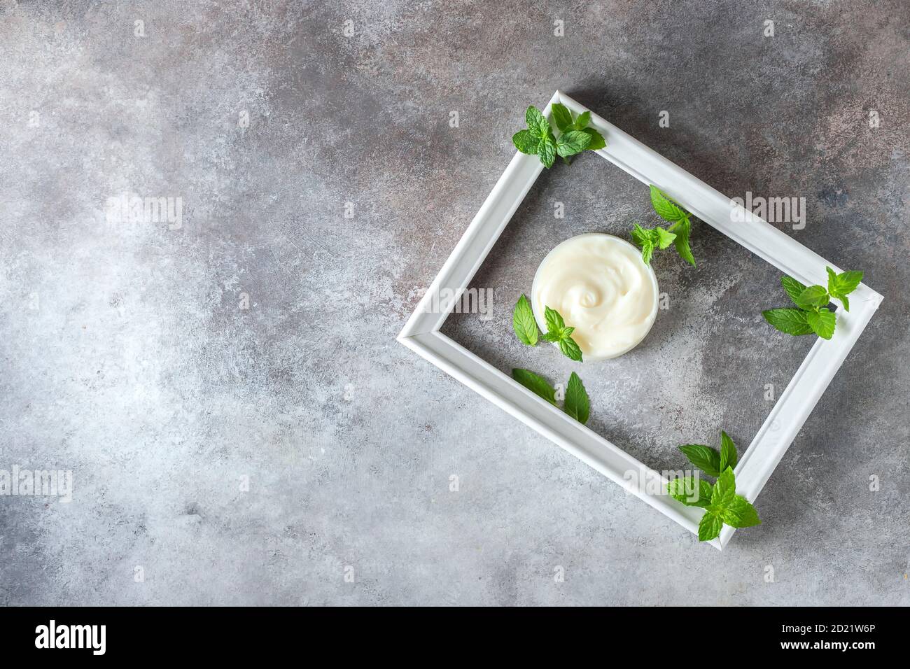 Composition of mint cosmetic products in a jar and green leaves of ...