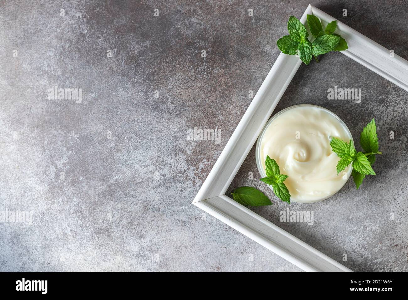 Composition of mint cosmetic products in a jar and green leaves of ...