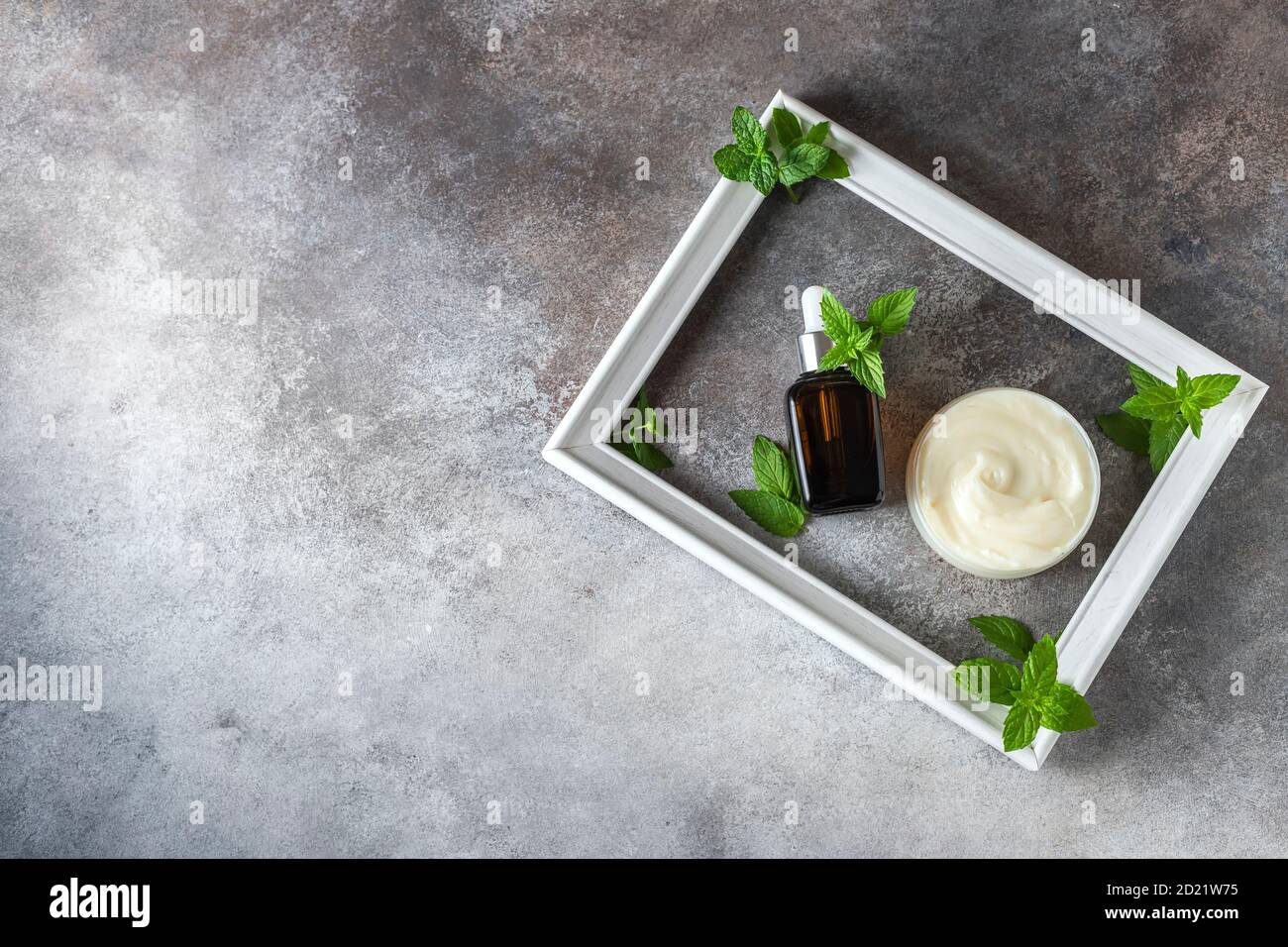 Composition of mint cosmetic products in a jar and green leaves of ...
