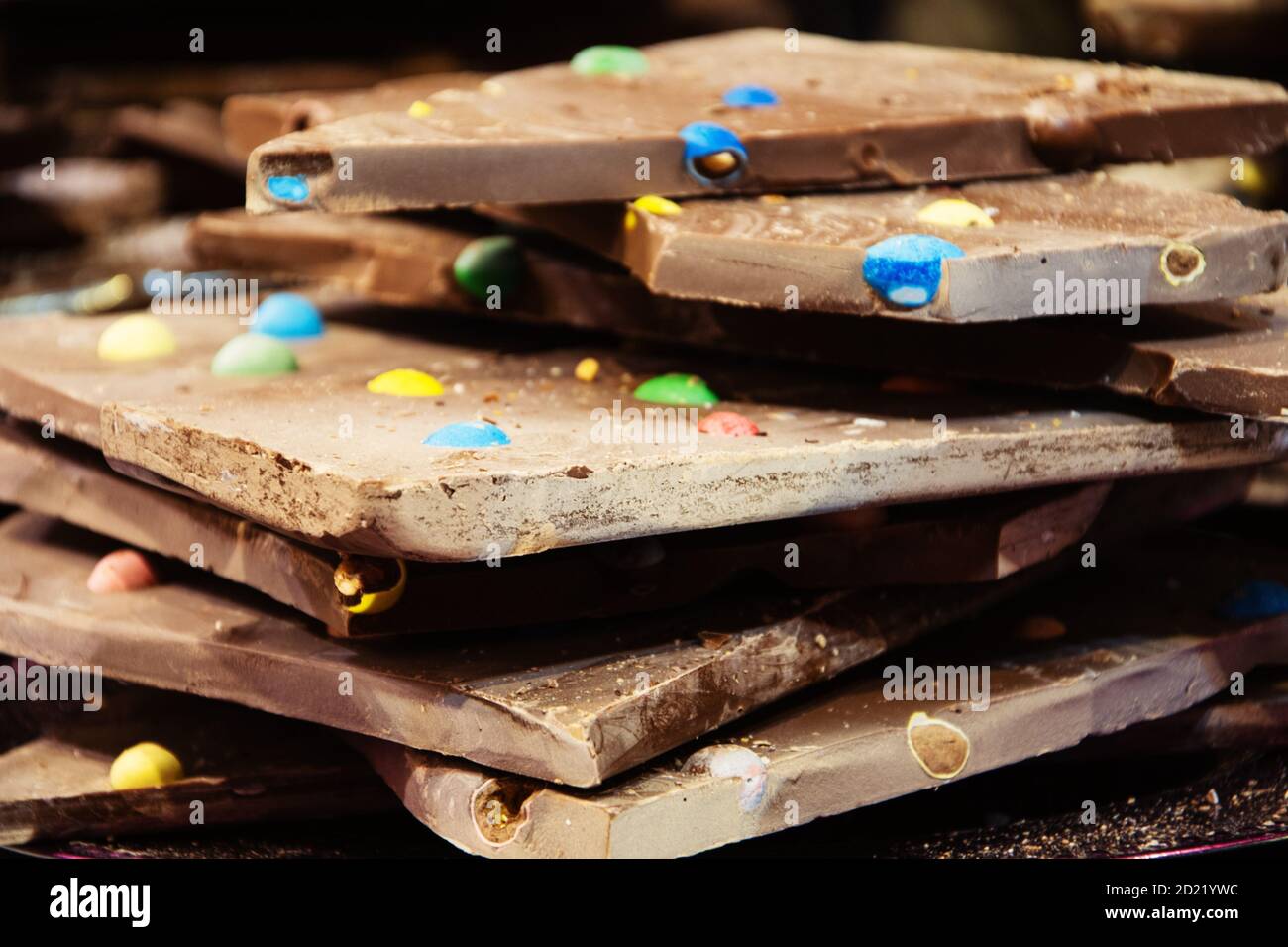 Chocolate filled with colorful candies background. Sweet temptation and ...