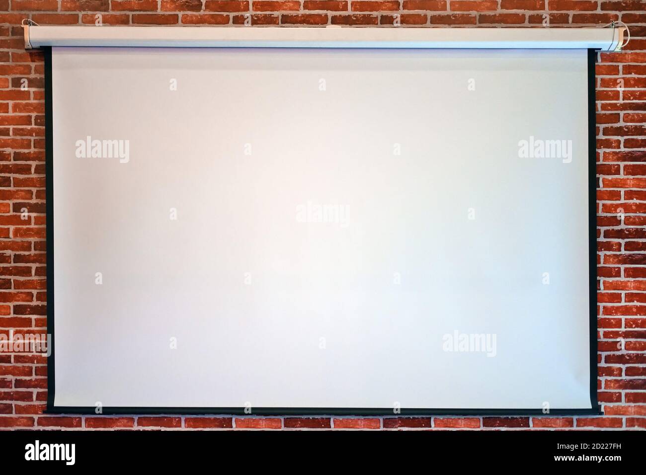 White canvas on a brick wall for showing movies on a projector, copy ...