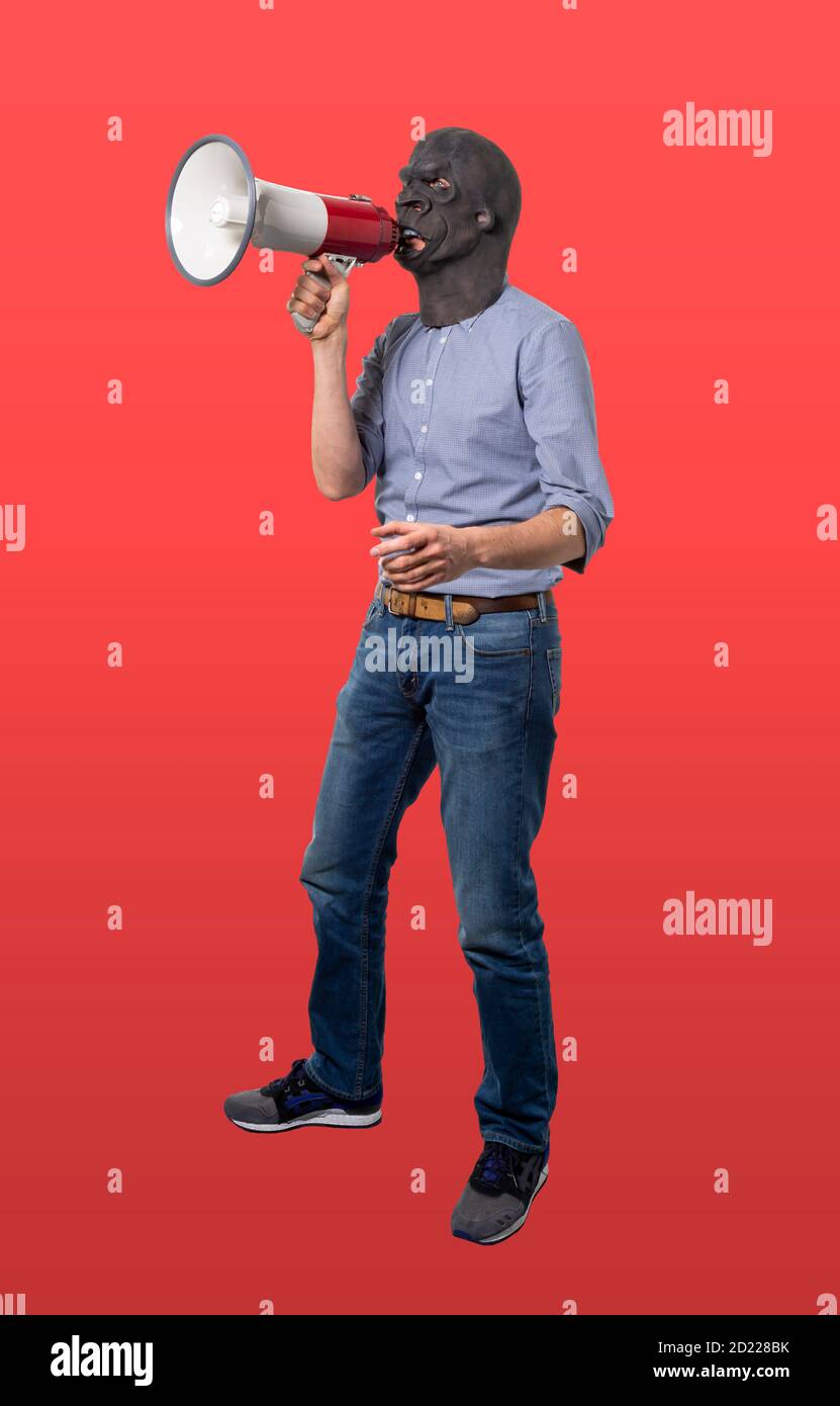 Man wearing gorilla mask speaking through megaphone. Isolated red ...