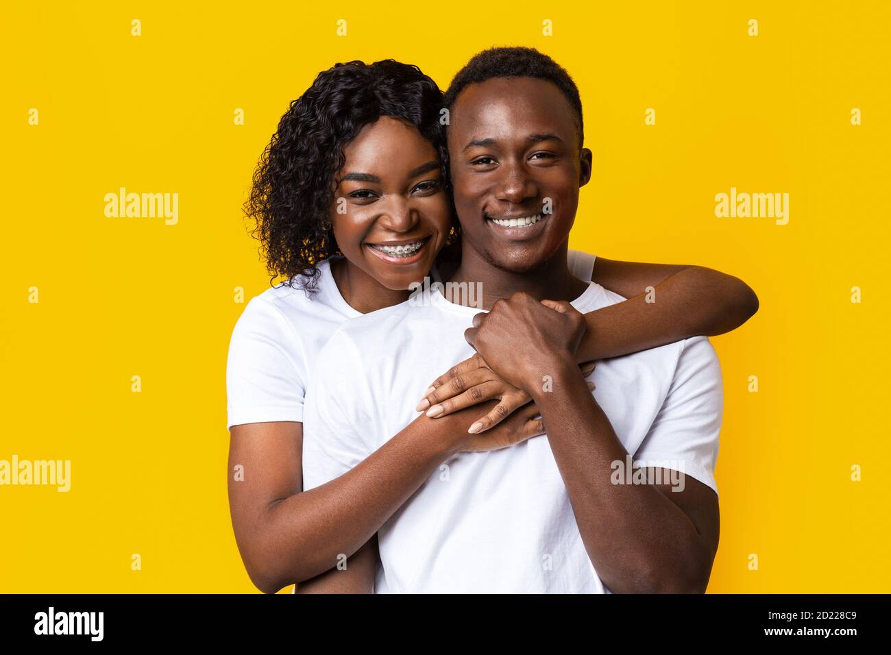 Happy black couple in love embracing on yellow Stock Photo - Alamy