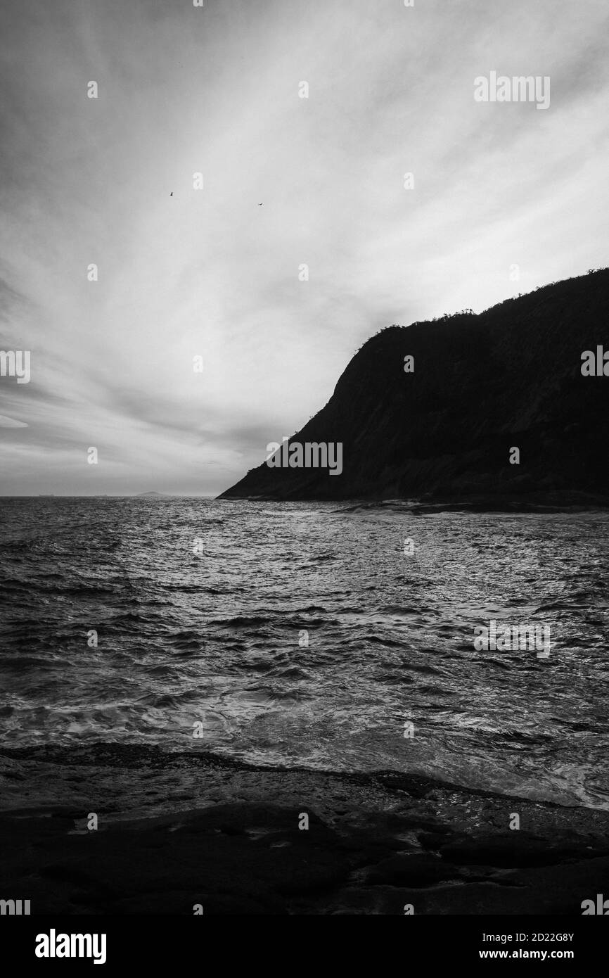 Vertical greyscale shot of the ocean and the beach in Rio de Janeiro ...
