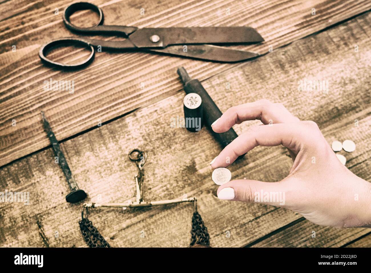 Retro silver coin in women's hand. Tools to create vintage money by ...