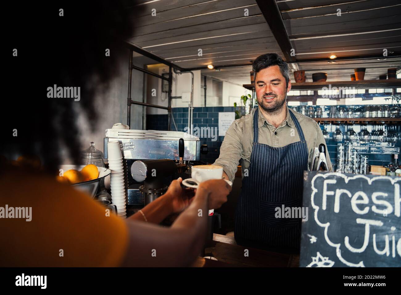 African American female collecting coffee from smiling handsome male ...