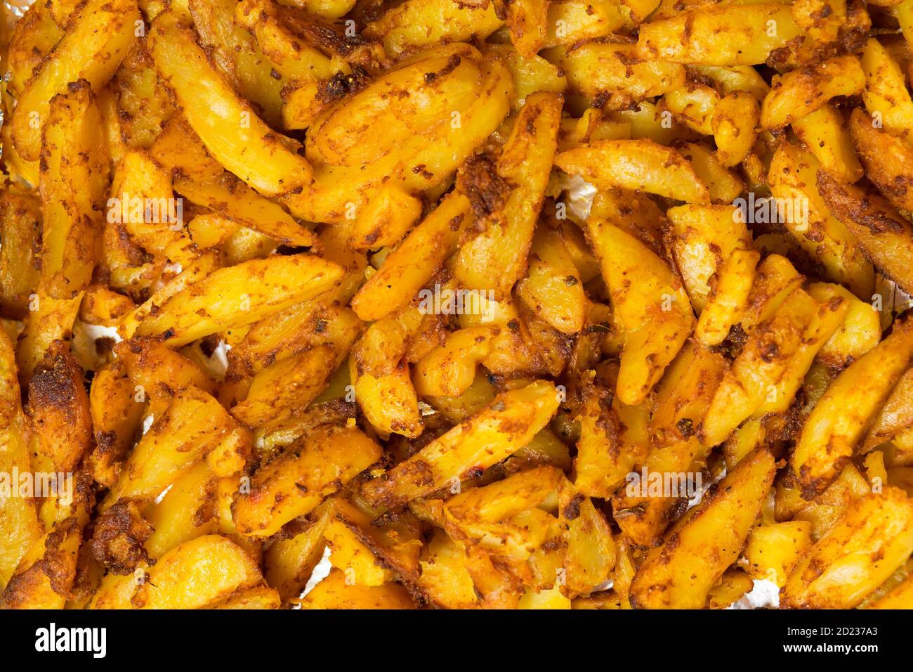 yellow crispy baked potatoes in the oven with spices Stock Photo - Alamy