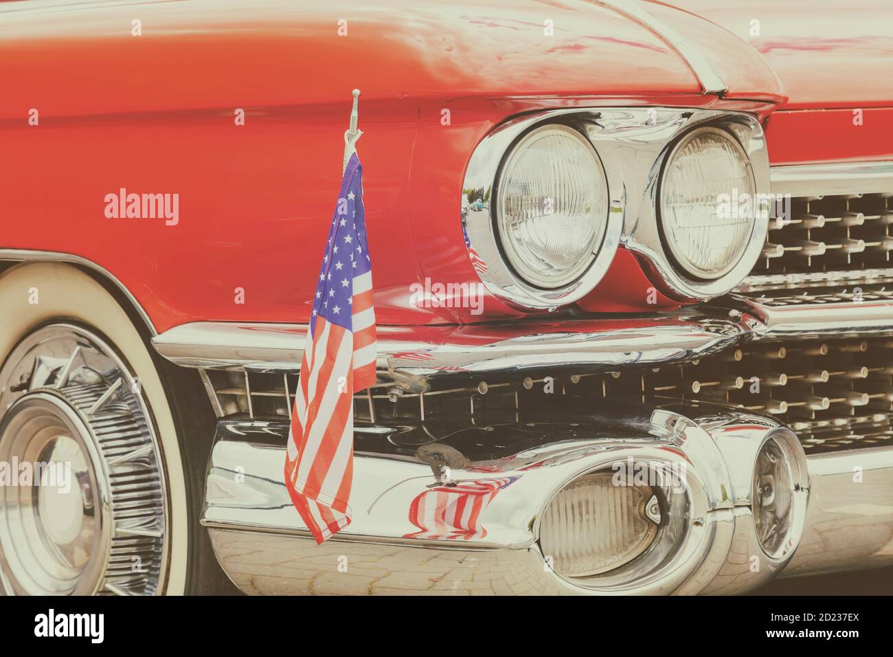 Classic red front of an old car with the American flag attached to the ...