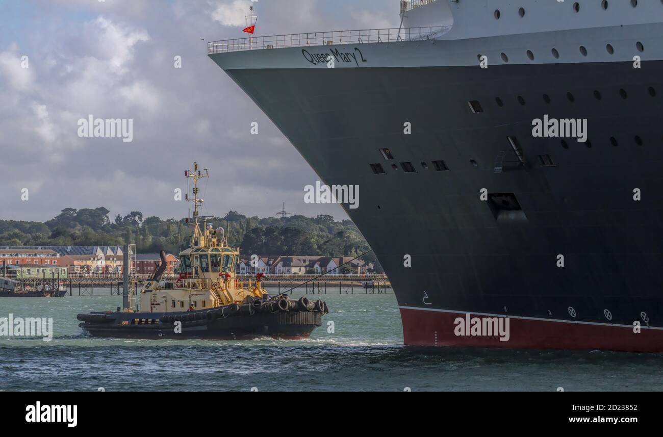 Powerful Little Tugboat Guiding, Pulling And Towing The Queen Mary Two ...