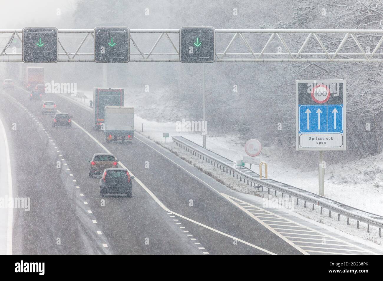 Dutch highway during winter snow with road signs informing about the ...