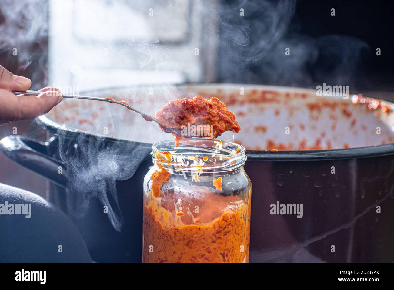 pouring fresly cooked ajvar into the jar with spoon Stock Photo - Alamy
