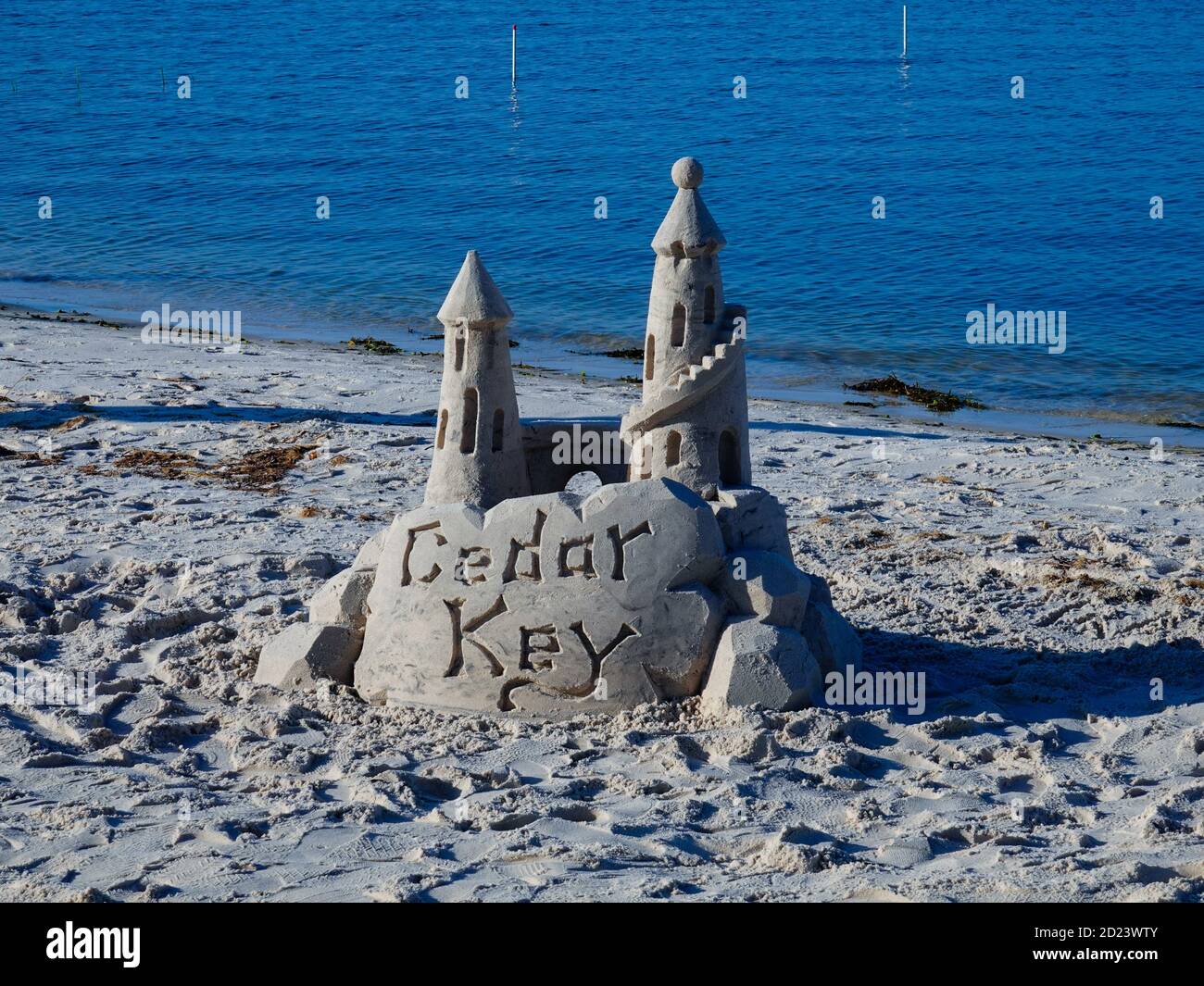 Freshly built and fancy sand castle with the name of the town. Beach at ...