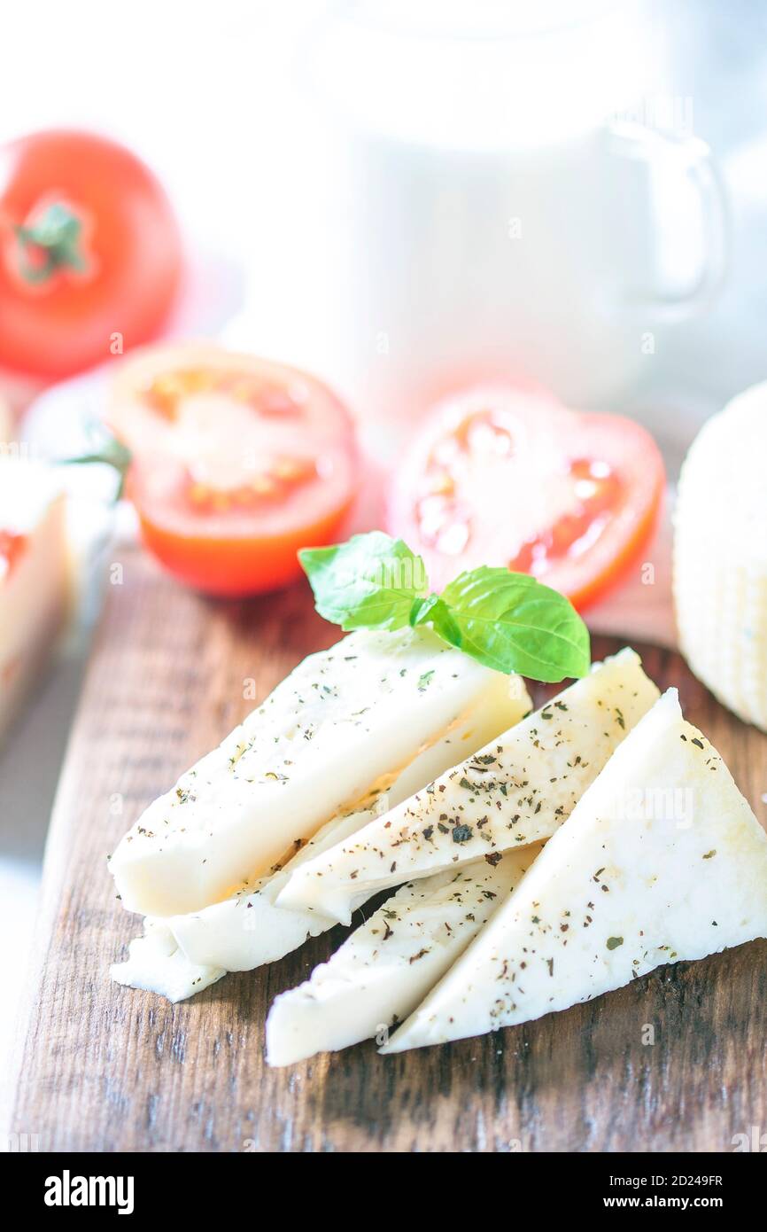 Homemade cheese halloumi with herbs on a light background. Copy space ...