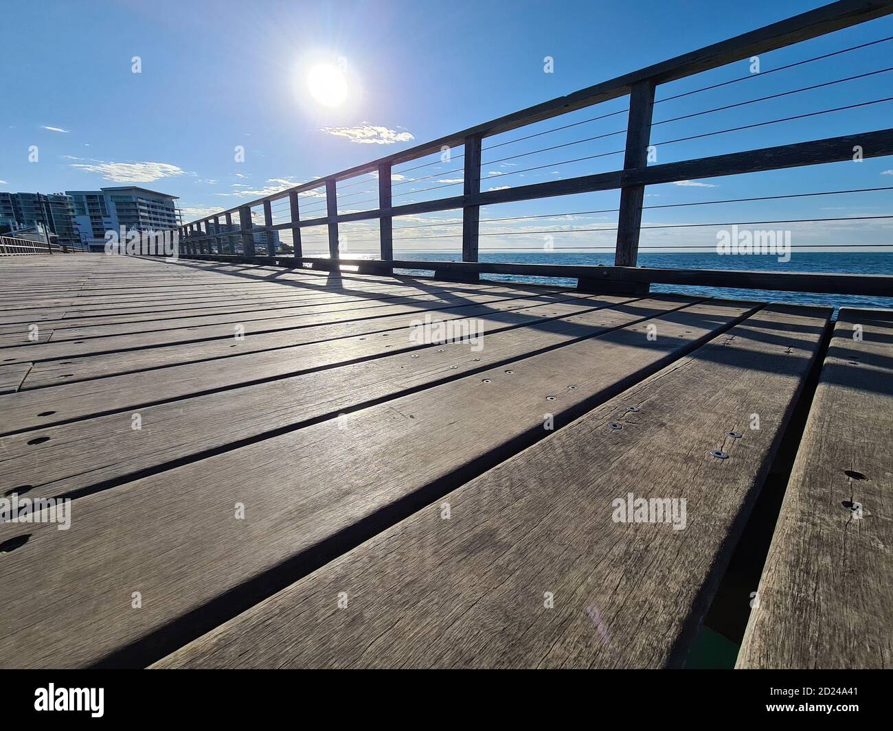 Long wooden bridge built over a sea leading to resort buildings Stock ...