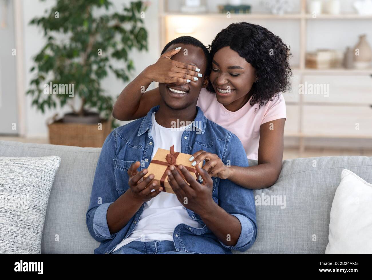 African woman giving gift box to her man Stock Photo - Alamy