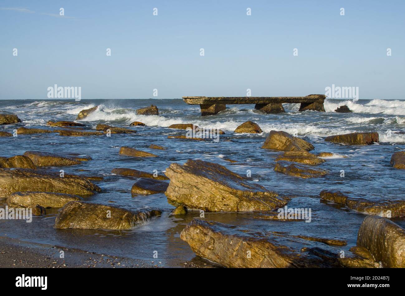 Beach landscape with broken pier and stones Stock Photo - Alamy