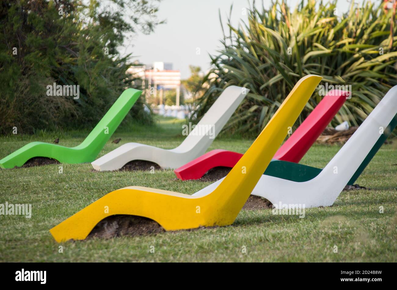 Colorful cement chairs in a public park Stock Photo - Alamy