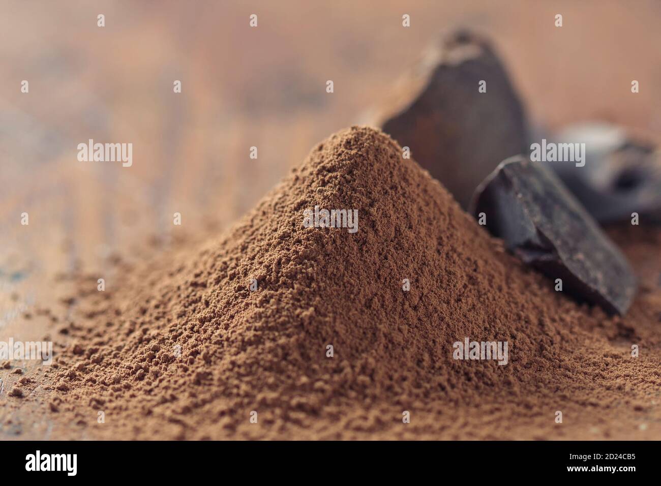 dark chocolate, cocoa solids and cocoa powder over wooden background ...