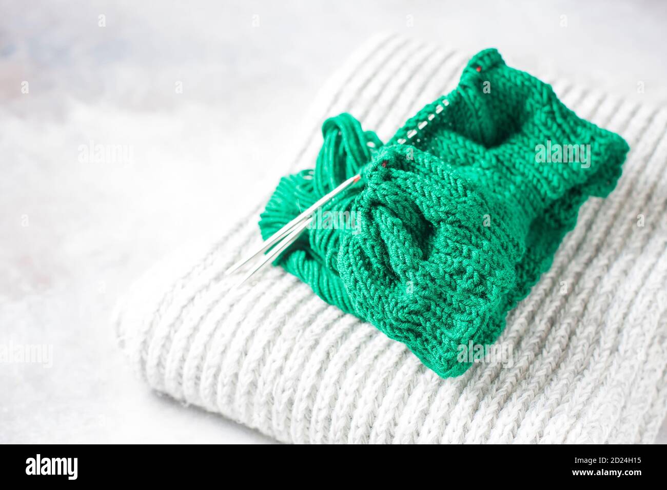 Green knitting yarn and knitting needles close-up Stock Photo - Alamy