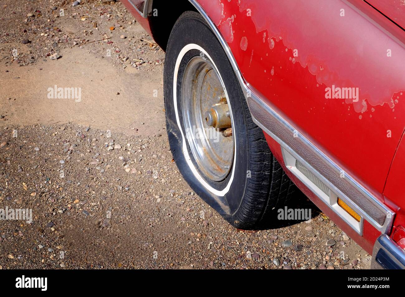 Flat tire red car vehicle deflated rubber wheel Stock Photo - Alamy