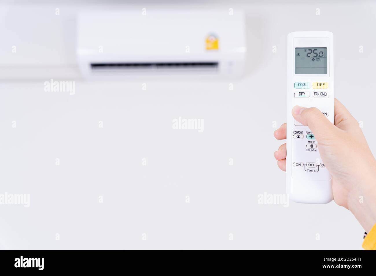 Human hand is using white remote of air conditioner for turn on or ...
