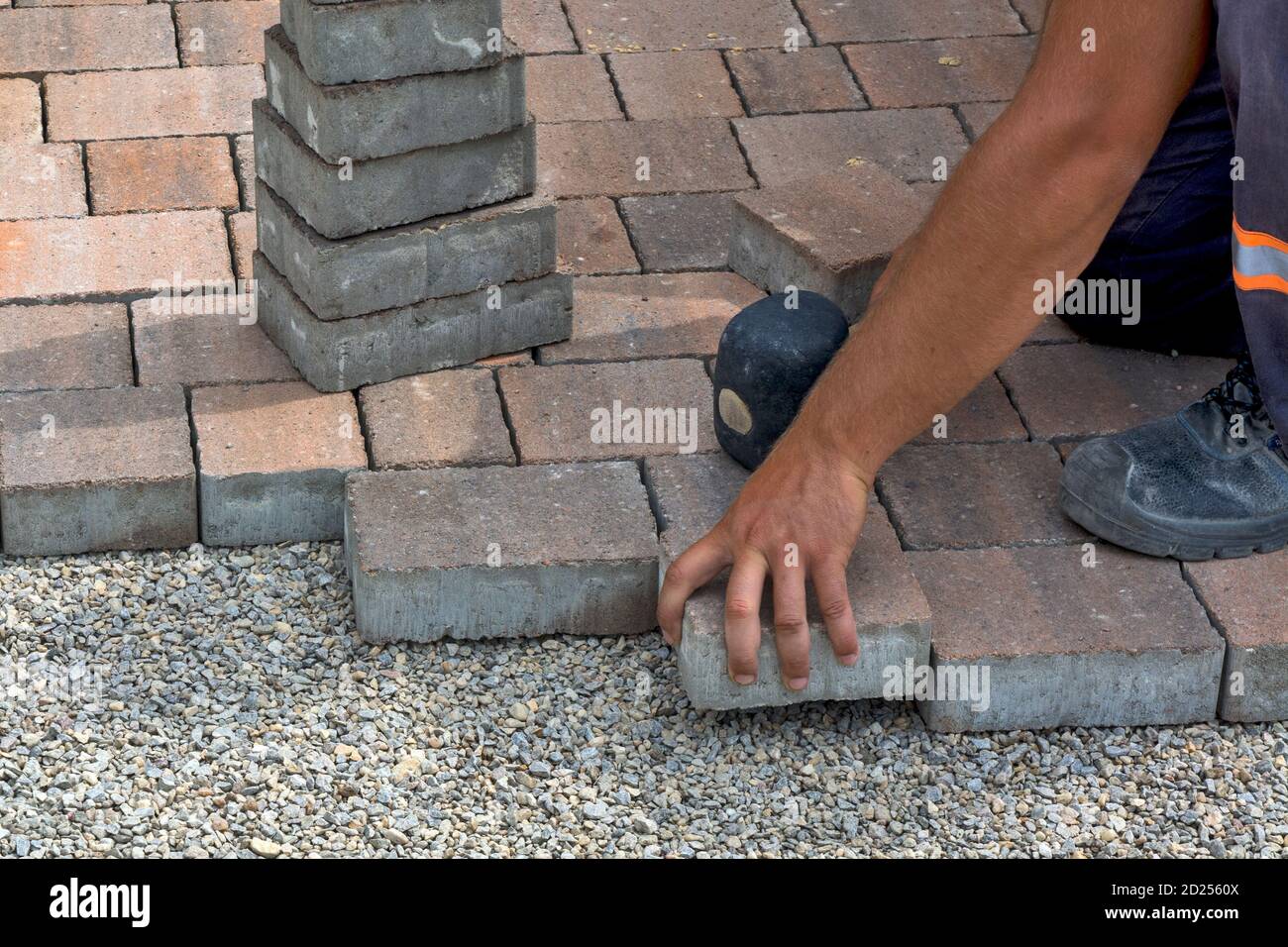 Master lay and install floor bricks on a public surface. The base is ...