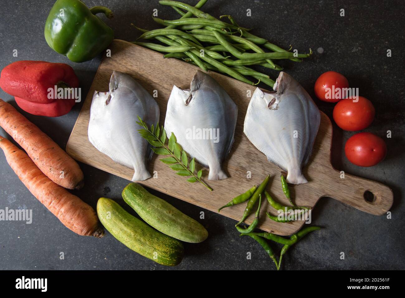 Raw pomfret fish and vegetables Stock Photo - Alamy