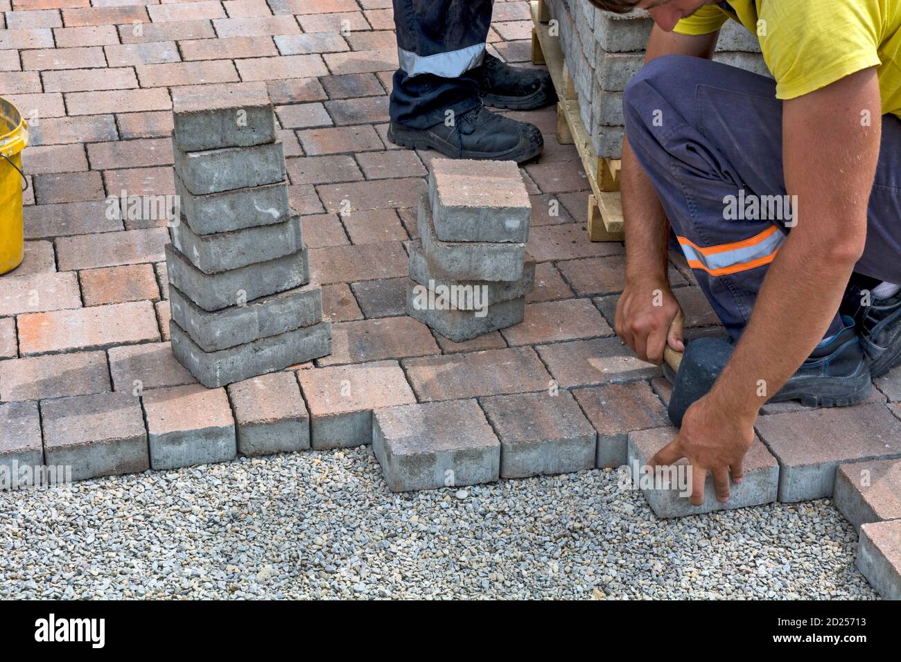 Master lay and install floor bricks on a public surface. The base is ...