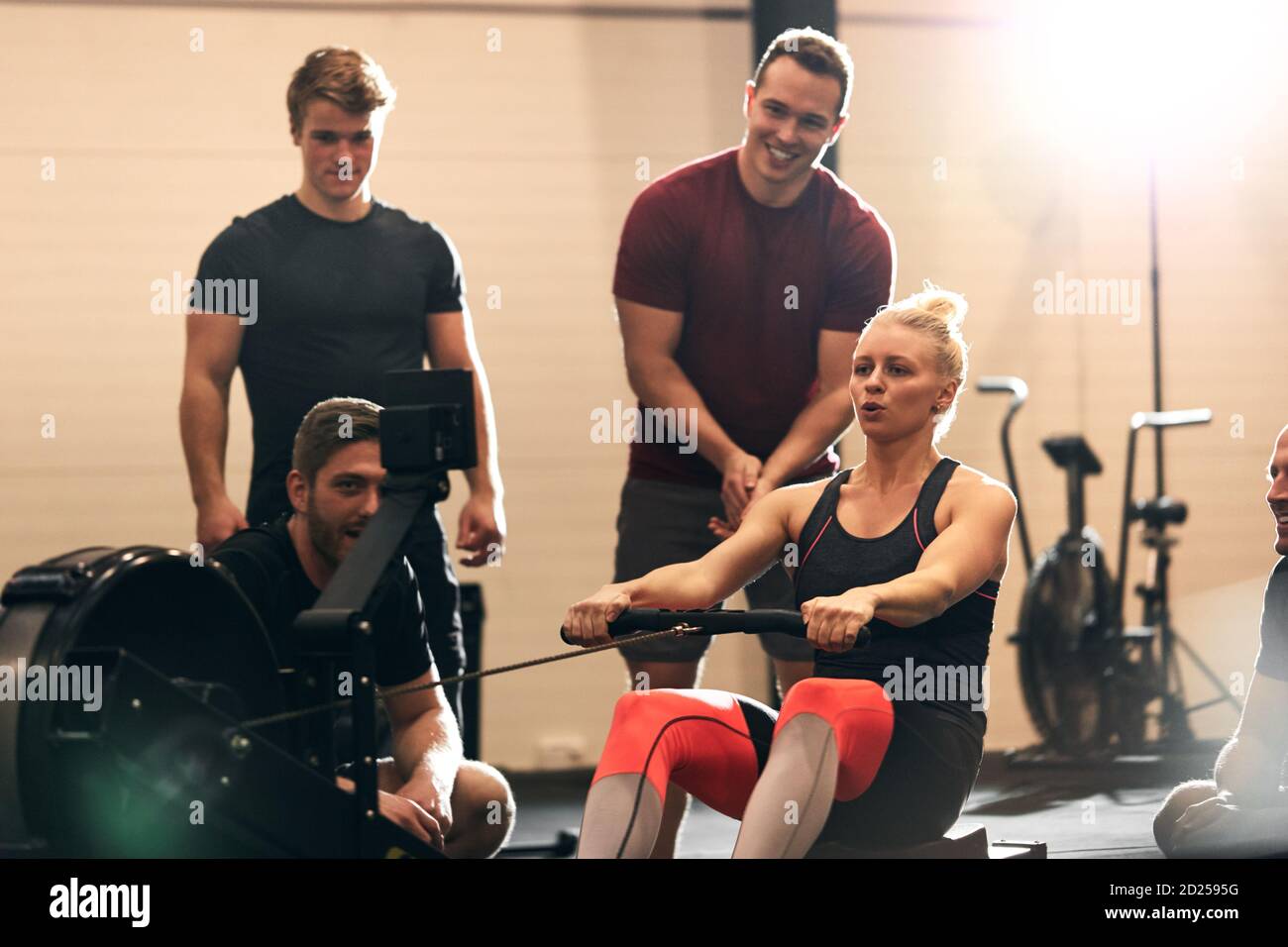 Fit young woman being supported by her smiling gym friends during a ...