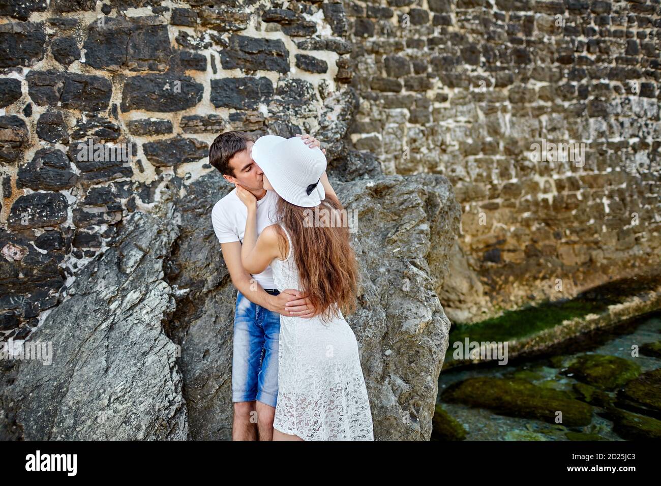 Couple in love kissing on the rocks against the background of an old ...