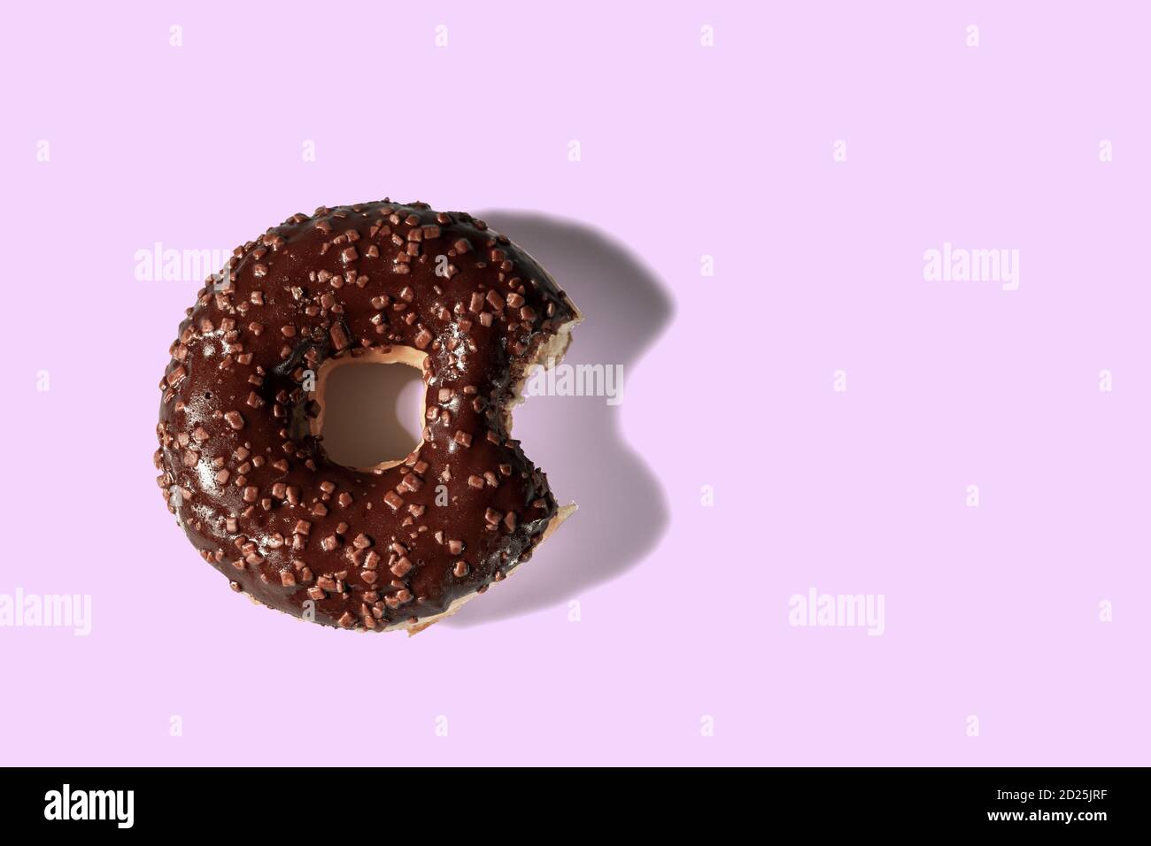 Close up view of bitten chocolate donut on pink background isolated ...