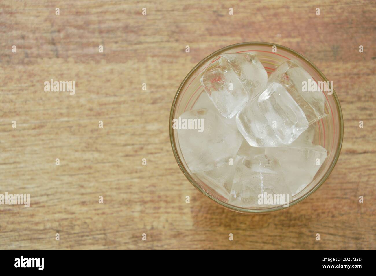 ice cube in drinking glass on table Stock Photo - Alamy