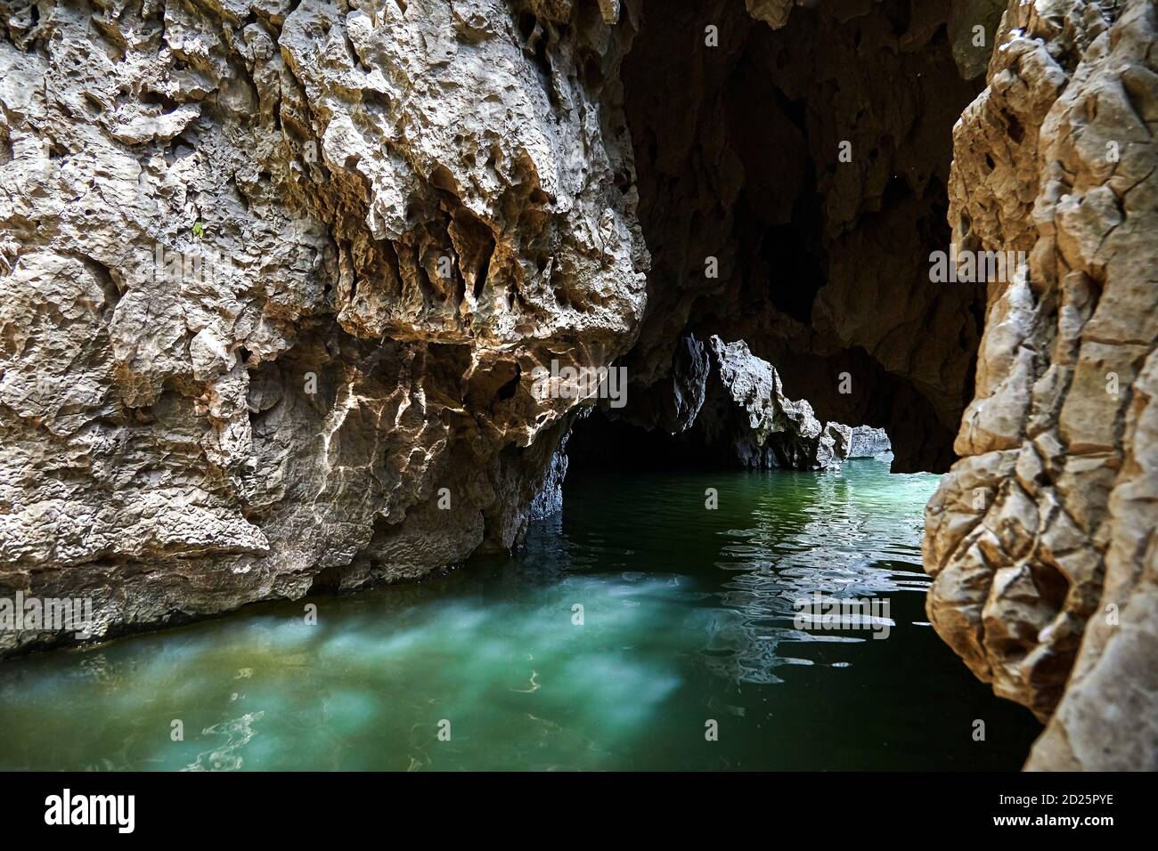 Cave in rock filled with river water. Glare on the stone surface of the ...