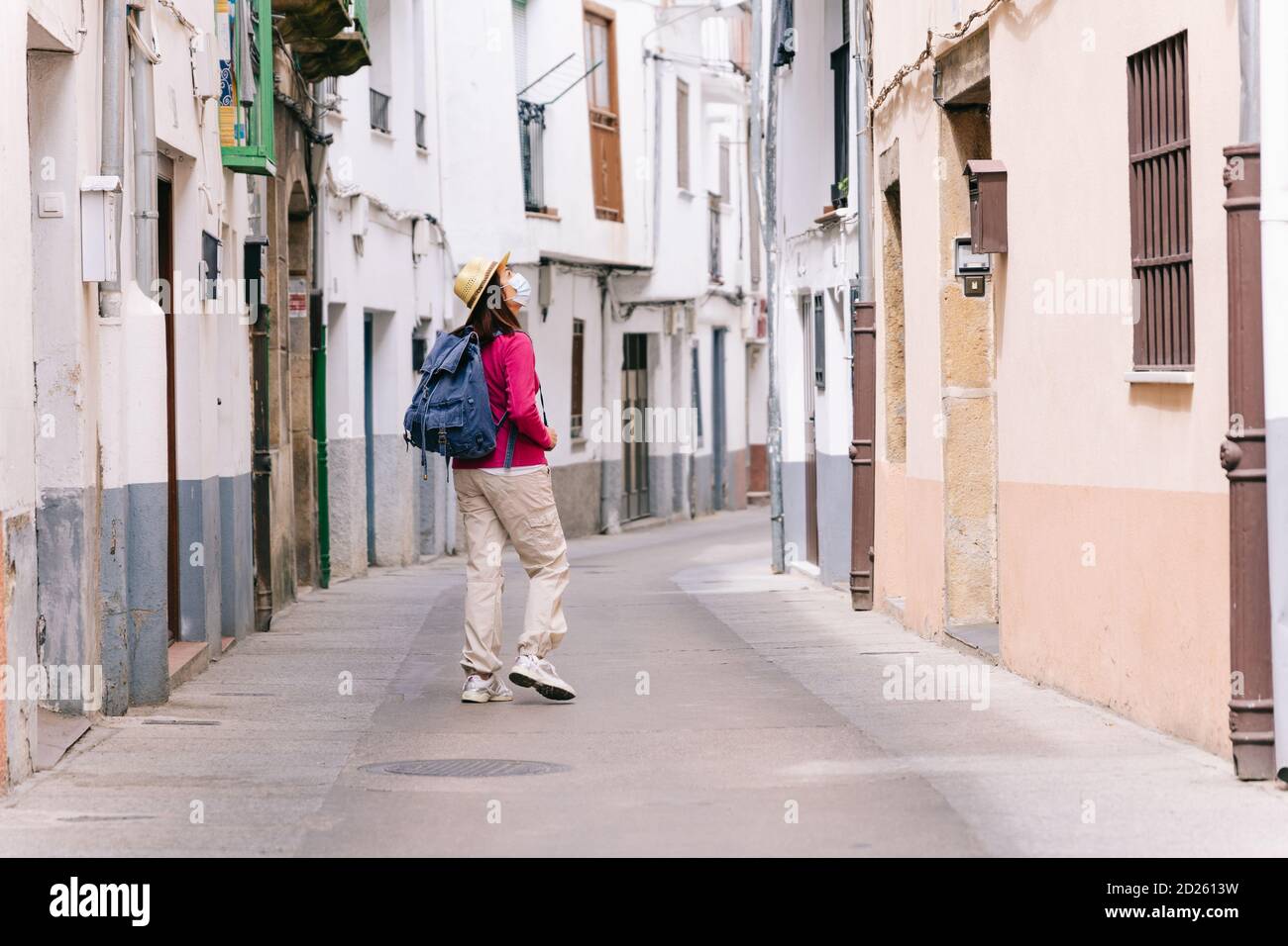 Woman sightseeing walking down a street Stock Photo - Alamy