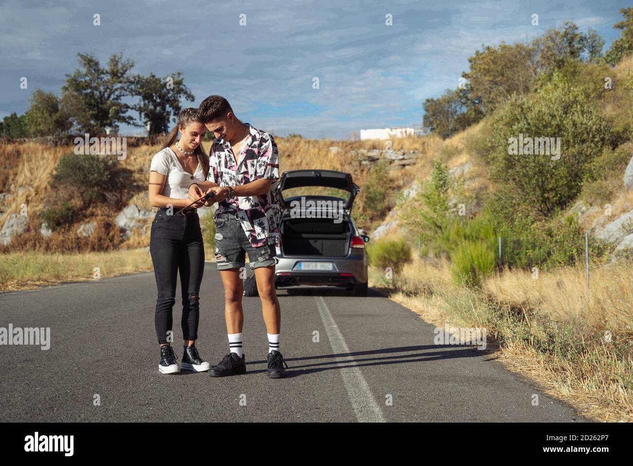 Couple trying to open the car triangle to signal a breakdown Stock ...