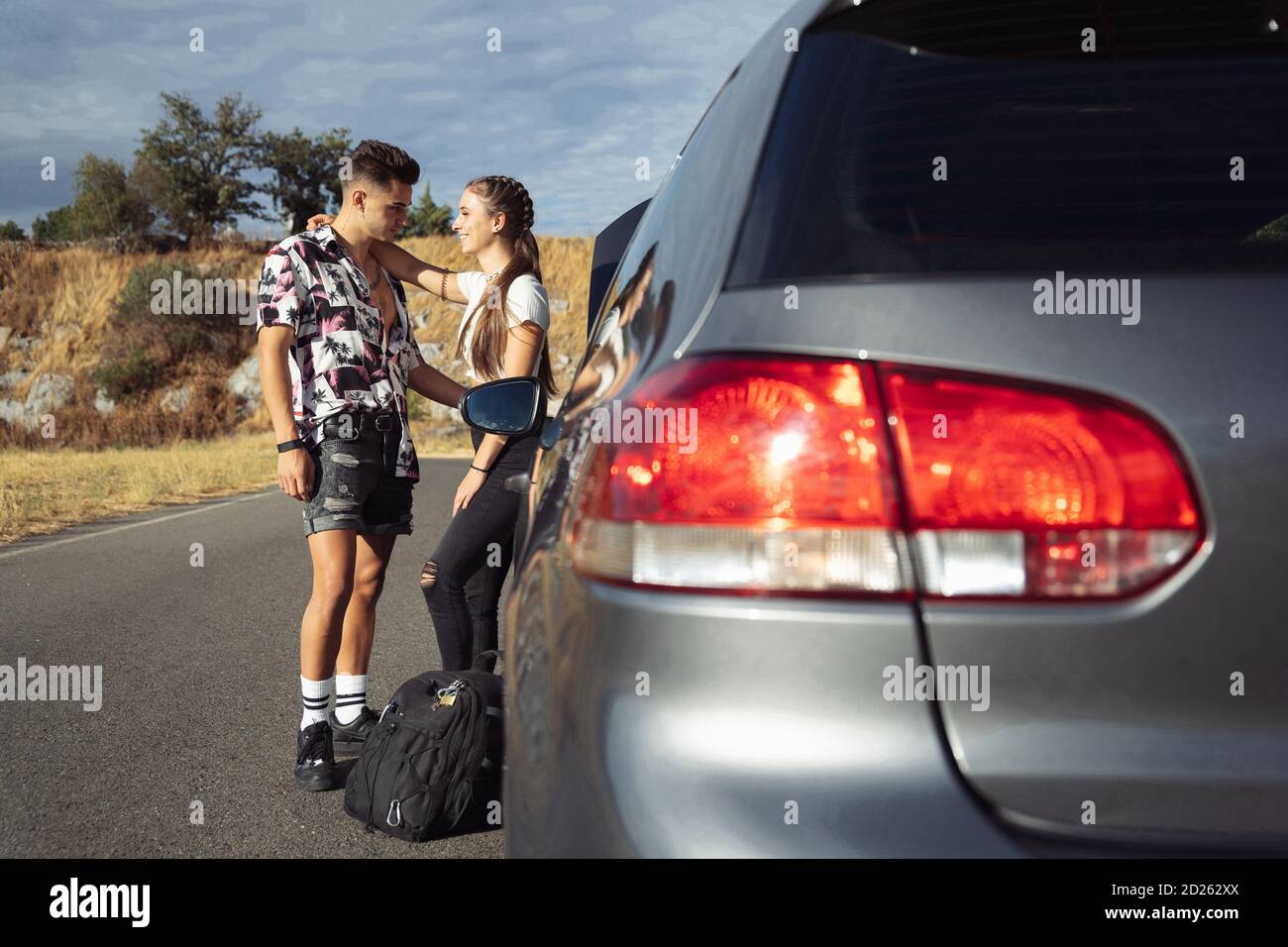 Couple leaning on car while waiting for tow truck Stock Photo - Alamy
