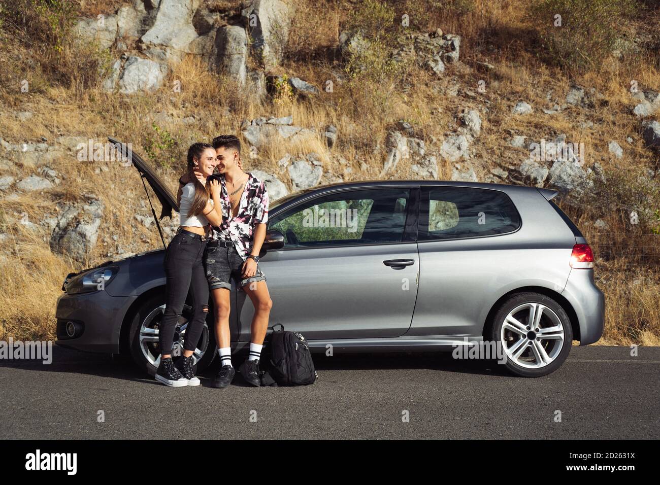 Couple leaning on car while waiting for tow truck Stock Photo - Alamy