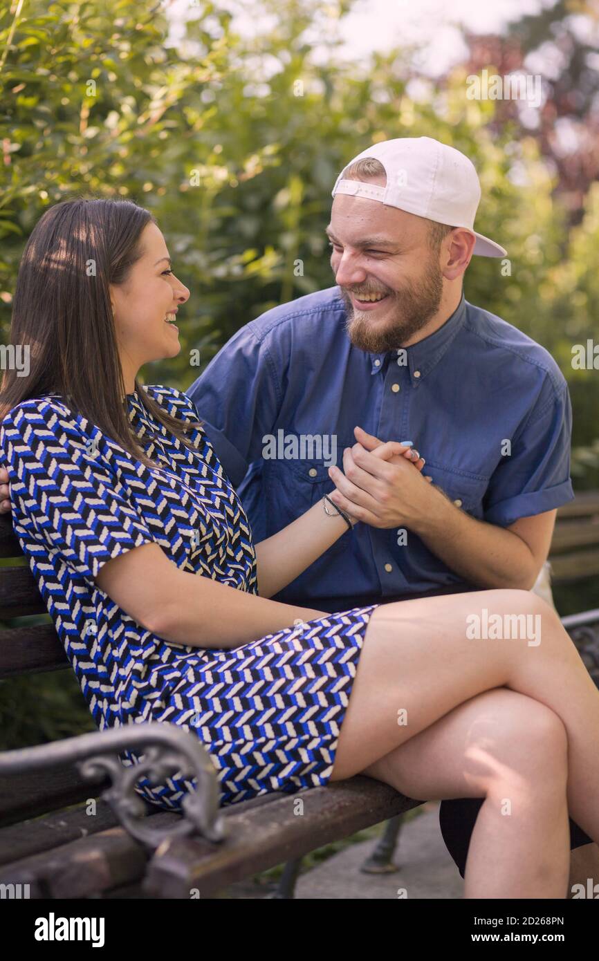 Romantic couple sitting on bench in park. Looking at each other Stock ...
