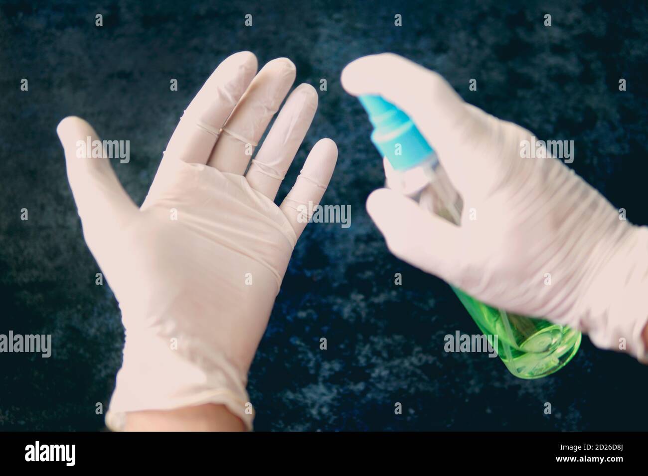 man hand in rubber surgical gloves holding antiseptic hand sanitizer on ...