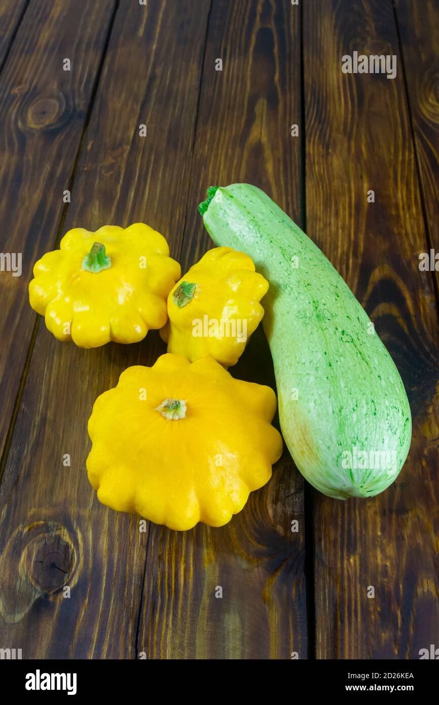 Zucchini and mini patty pan squashes on dark wooden table. Harvest ...