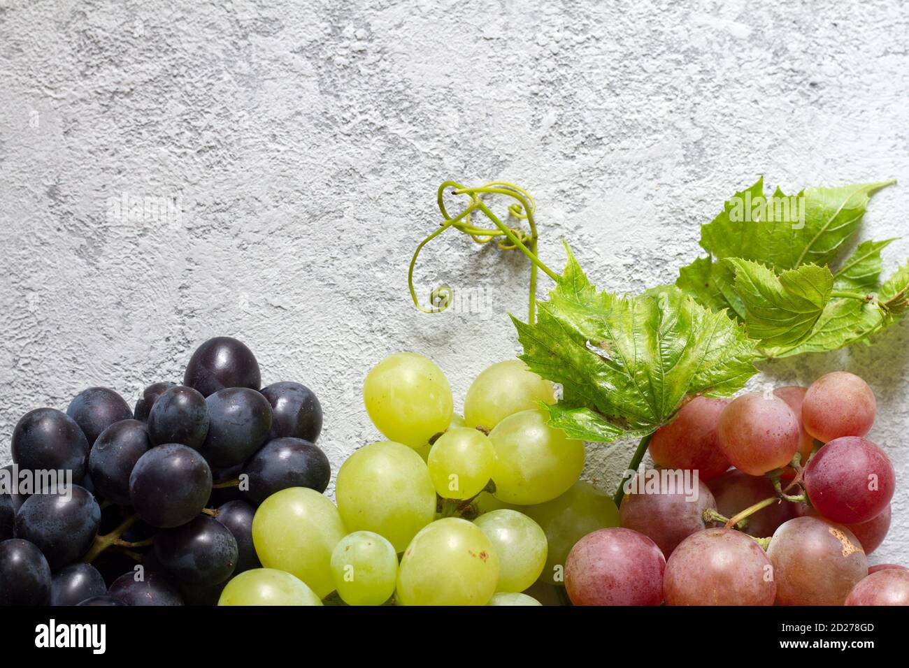 Mix of fresh ripe grapes on light background Stock Photo - Alamy
