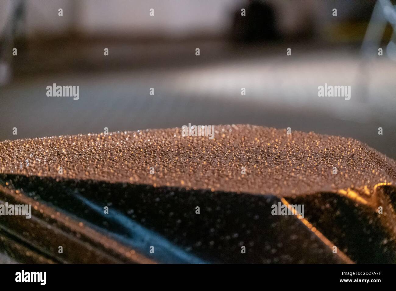 a drop of water and golden light on a flat surface in the evening Stock ...