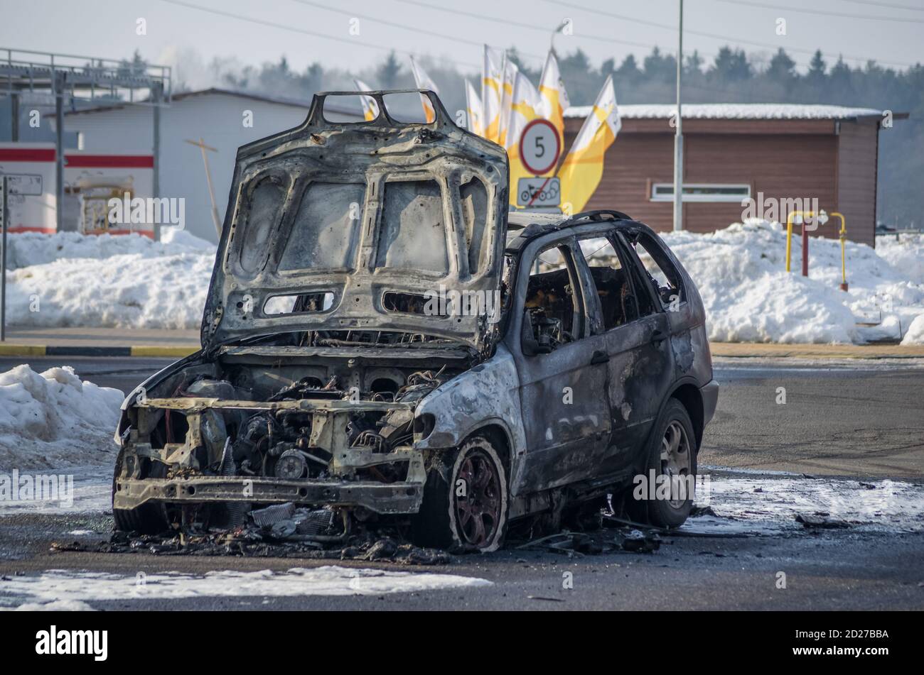 A burned-out car on the road on a sunny winter day Stock Photo - Alamy