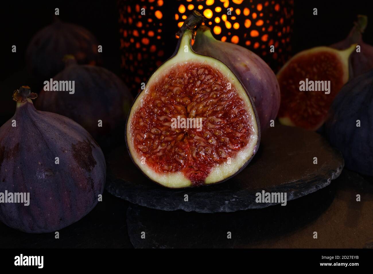 View on isolated raw ripe fig half with group of figs on black slate ...