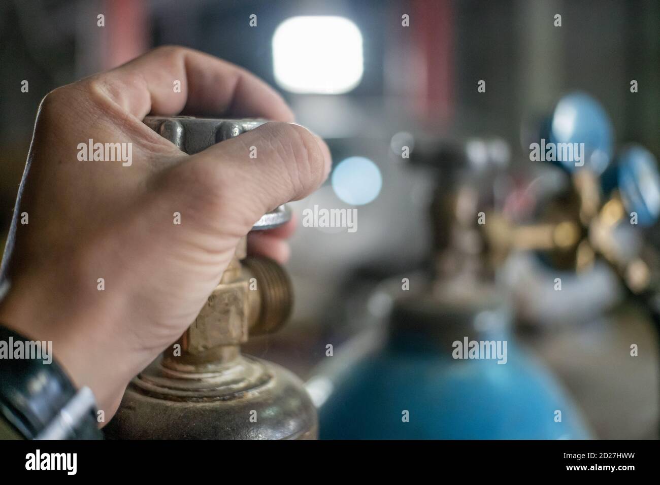 Closeup man's hand operating valve of gas cylinder for welding Stock ...