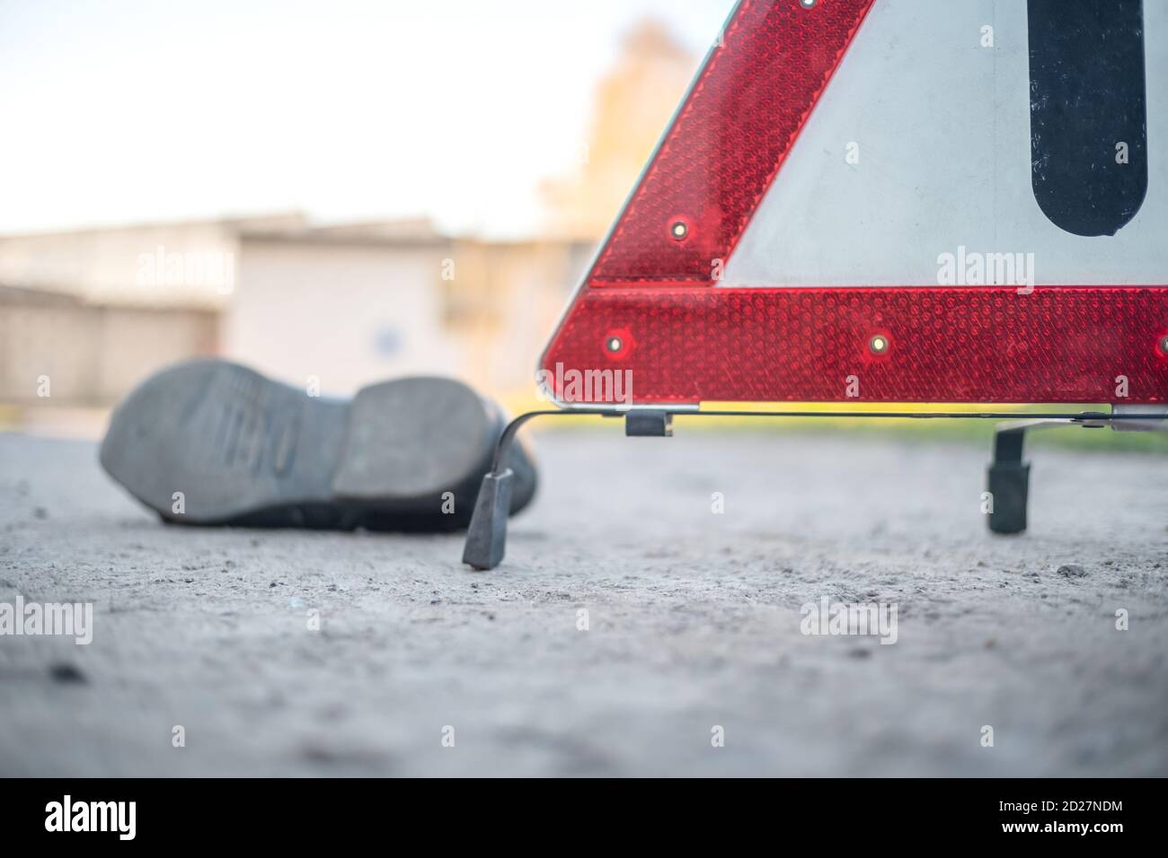 An accident on the road involving a person. Close up of a man's boot ...