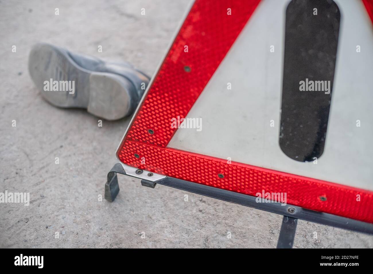 An accident on the road involving a person. Close up of a man's boot ...